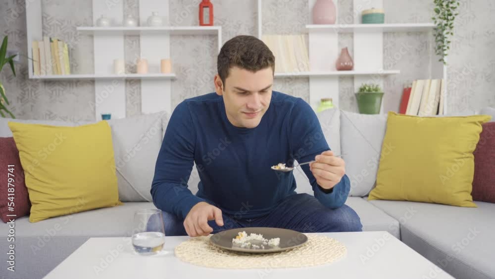 Hungry man is eating. Hungry man is eating and enjoying at home. Stock ...