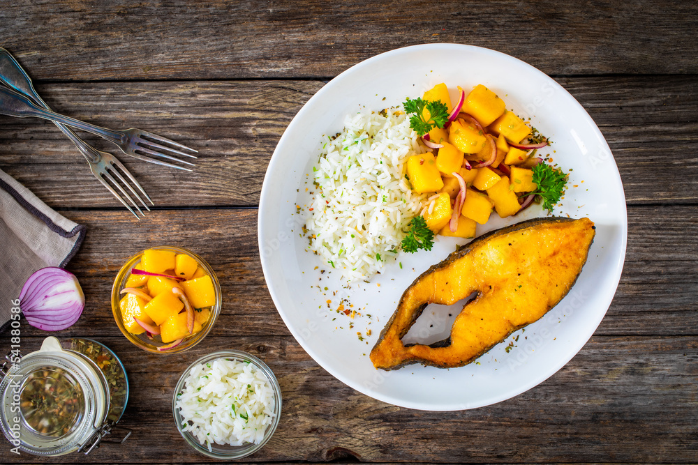 Fish dish - fried halibut with white boiled rice and avocado on wooden ...