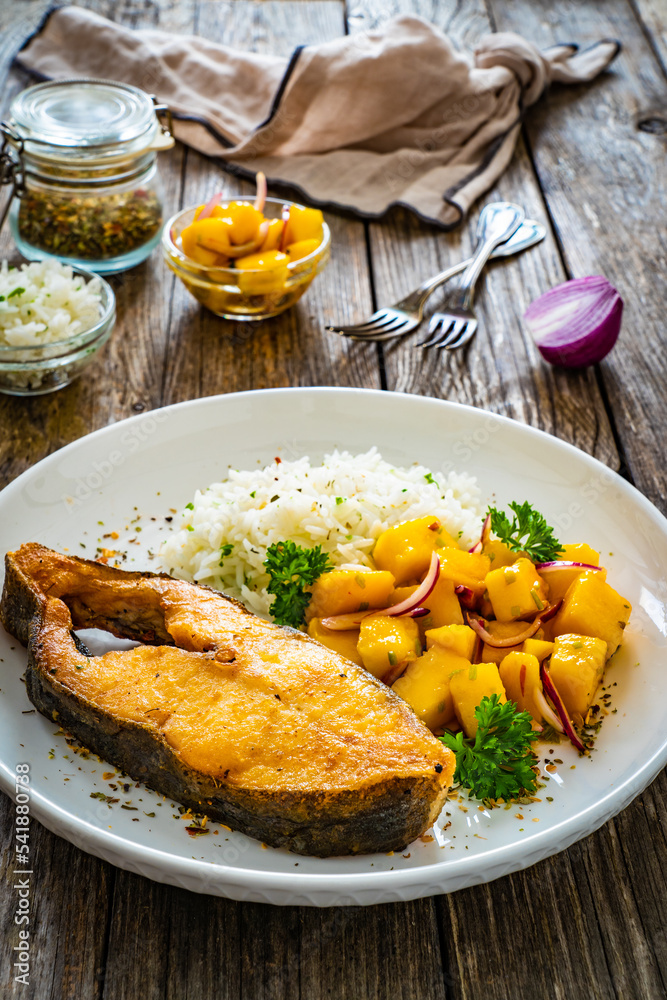Fish dish - fried halibut with white boiled rice and avocado on wooden ...