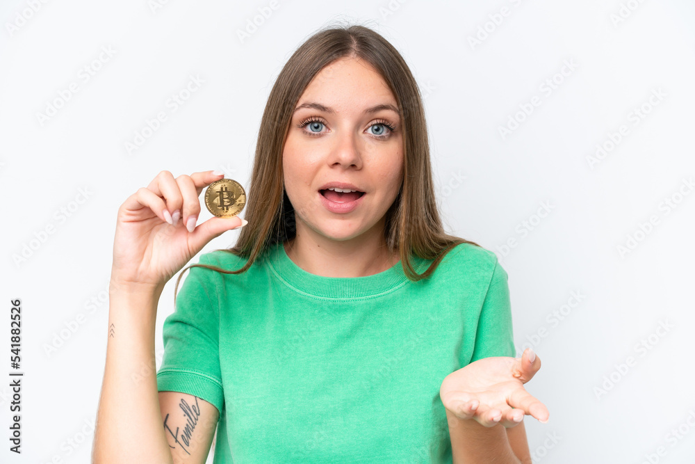 Young beautiful blonde woman holding a Bitcoin isolated on white ...