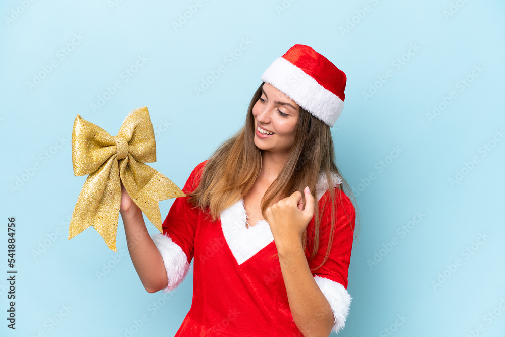 Young caucasian woman dressed as mama noel holding Christmas bow ...