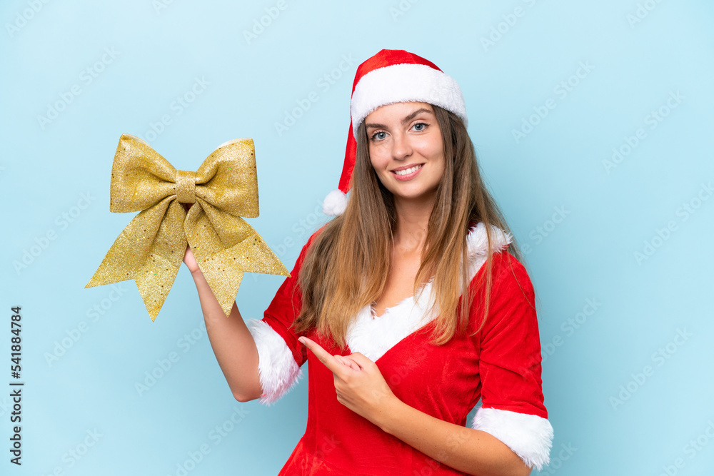 Young caucasian woman dressed as mama noel holding Christmas bow ...