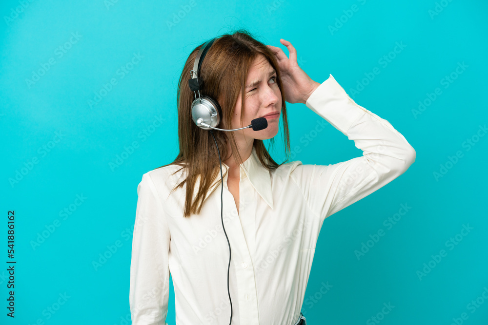 Telemarketer English woman working with a headset isolated on blue ...