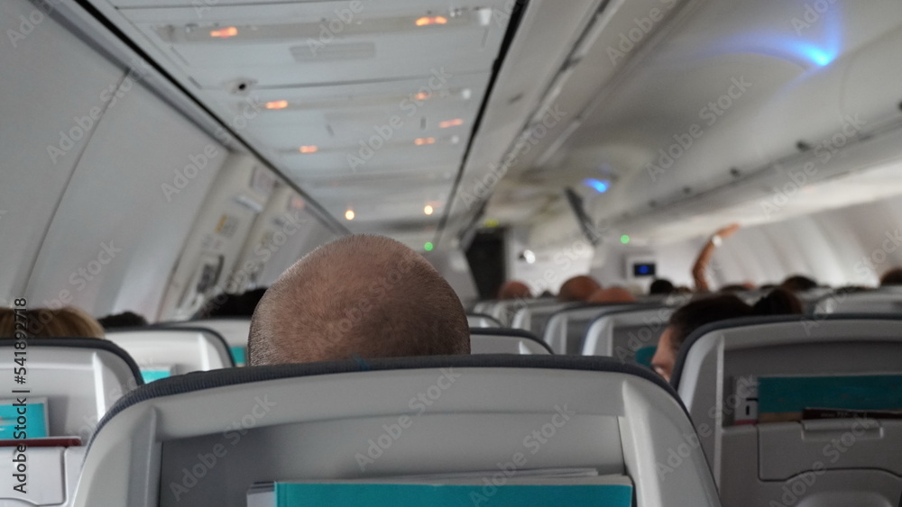 Passengers traveling by plane, shot from the inside of an airplane ...