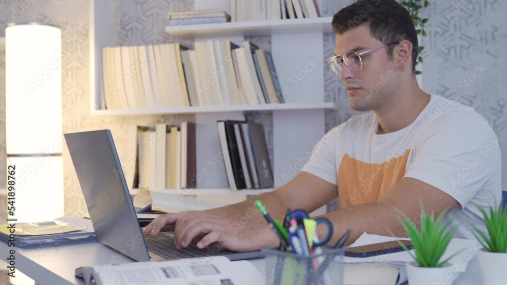 Student using computer at home. The student studying at the study desk ...