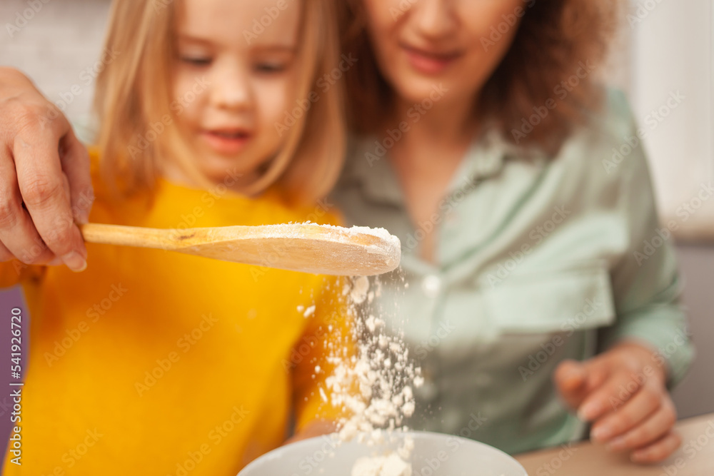 grandmother and granddaughter are making cake in kitchen, happy family ...