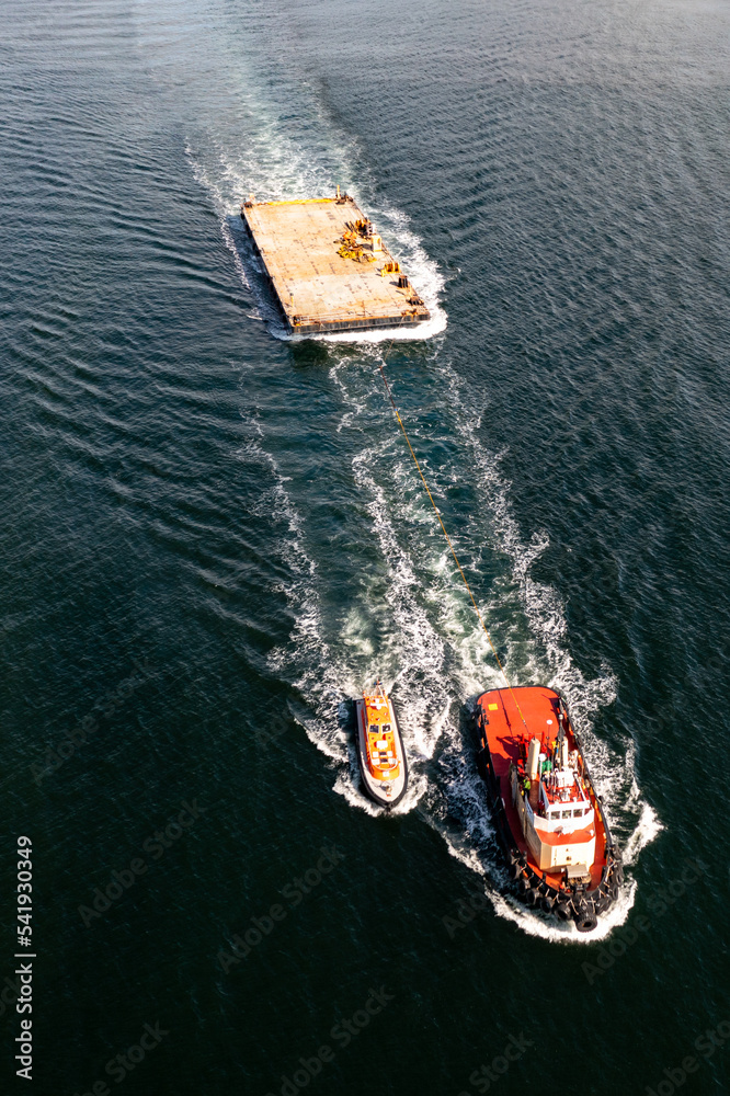 Tug boat towing barge with pilot boat alongside Stock Photo | Adobe Stock