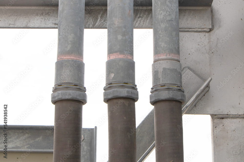 Aluminum grey fitting connected to plastic electrical cable conduit ...