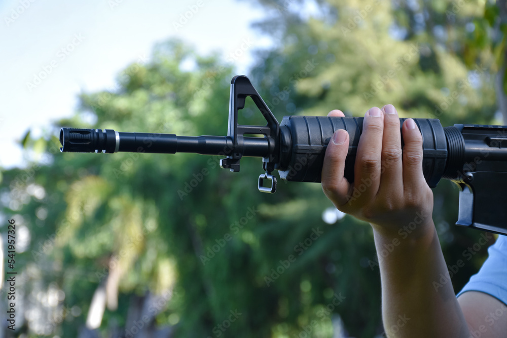 BB GUN or Airsoft Gun shooter holds the body of the gun and aiming the ...