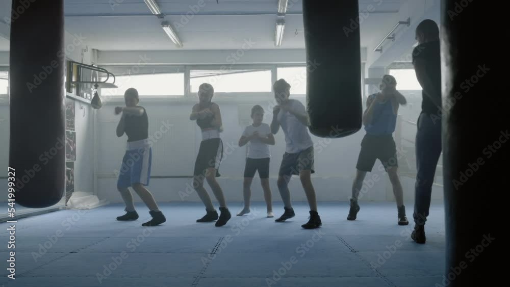 Boxing coach teaching boys and girls at kids fighting class, teenagers ...