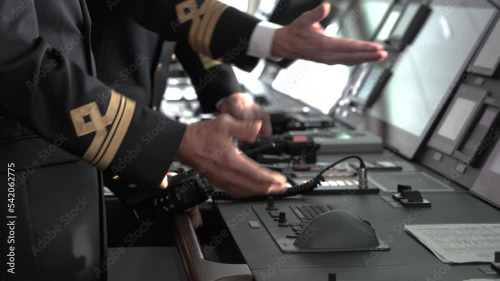 Ship's bridge. Officers show to screens of control panel. Hand holding ...