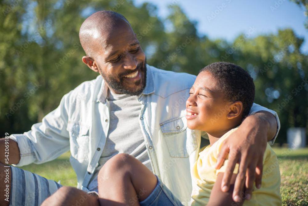 Smiling African American dad looking at his happy son. Young bearded ...