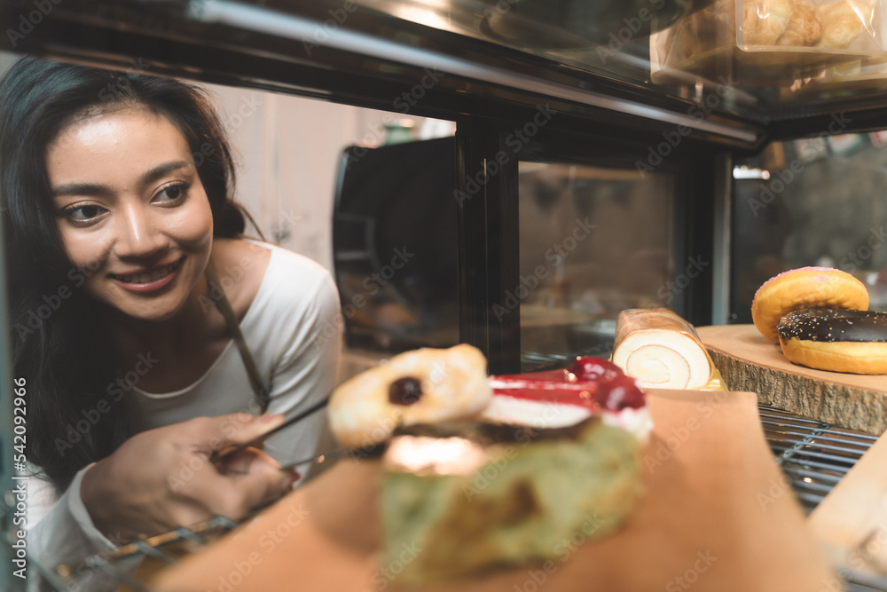portraits of beautiful waitress pick a donut from customer order and ...