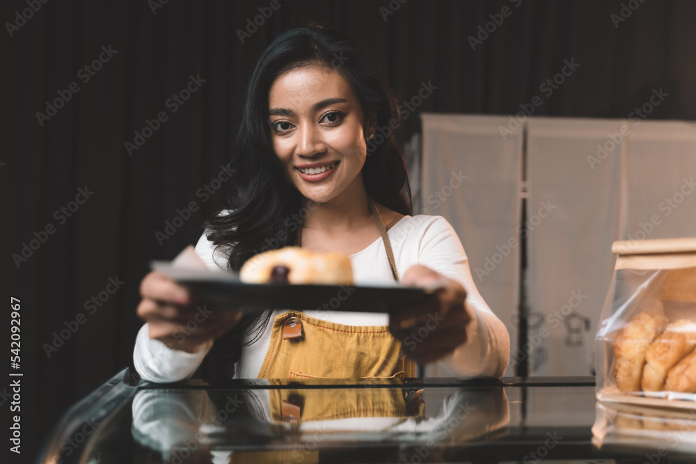 Foto de portraits of beautiful waitress pick a donut from customer order and put a donut on a ...