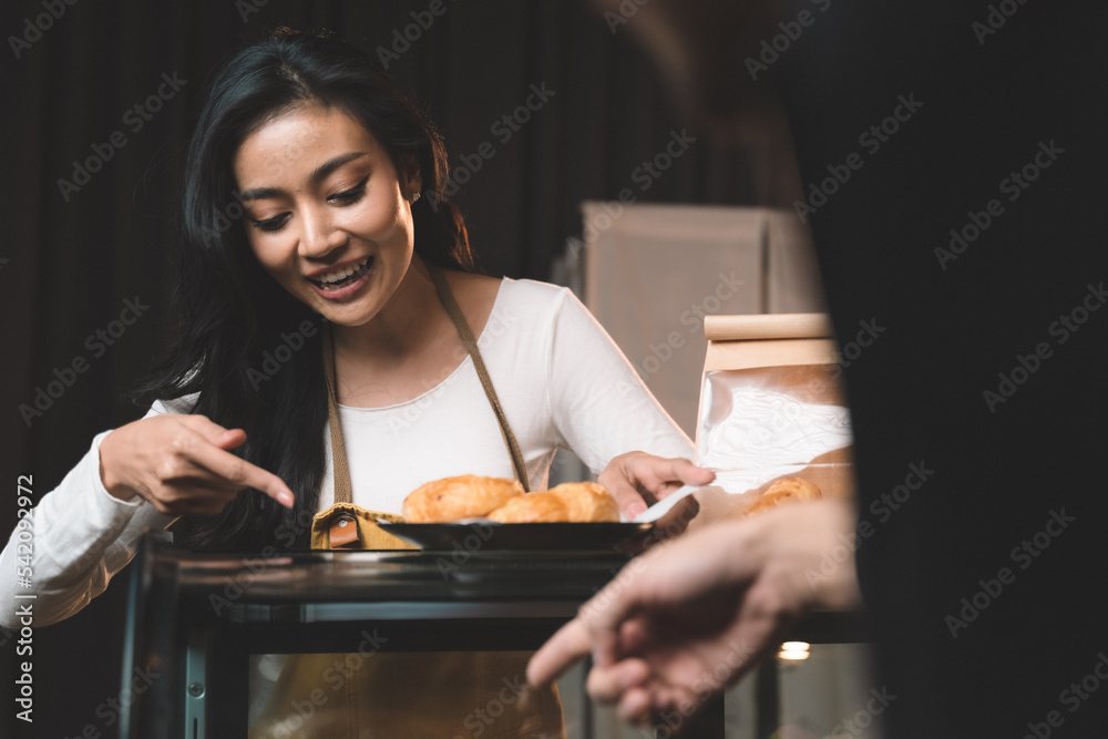 portraits of beautiful waitress pick a croissant from customer order ...