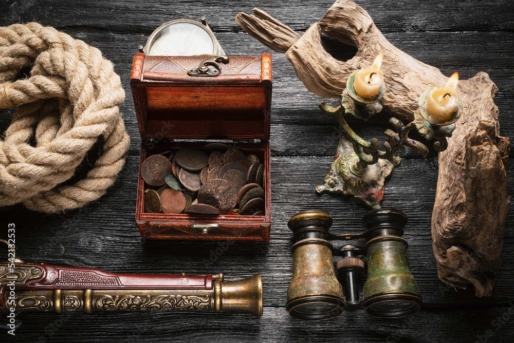 Treasure chest with the coins and musket on the old pirate table ...