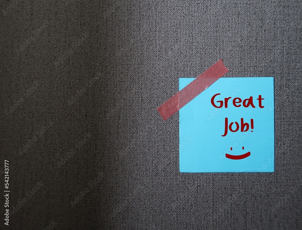 Blue note stick on grey copy space background with words GREAT JOB ...