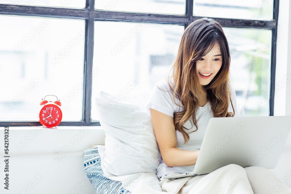 Smiling happy woman working on laptop computer sit near window in ...