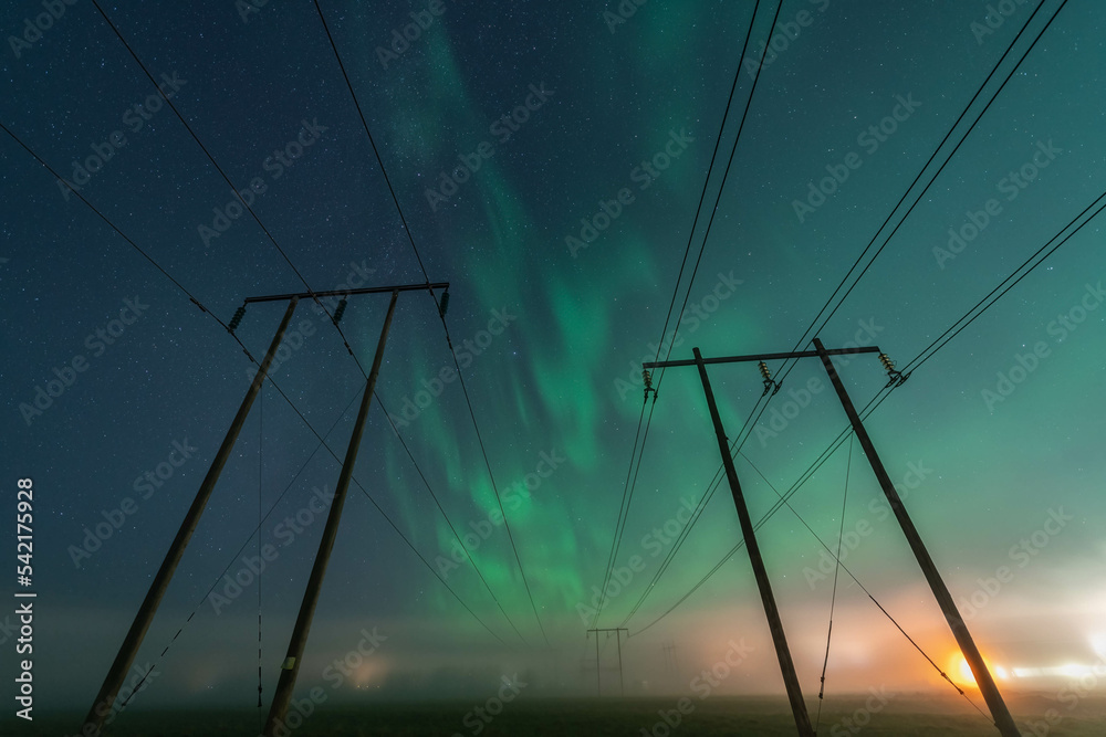 Beautiful night Aurora over two double wooden pole power lines in ...
