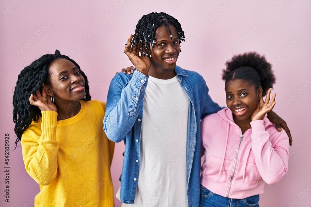 Group of three young black people standing together over pink ...