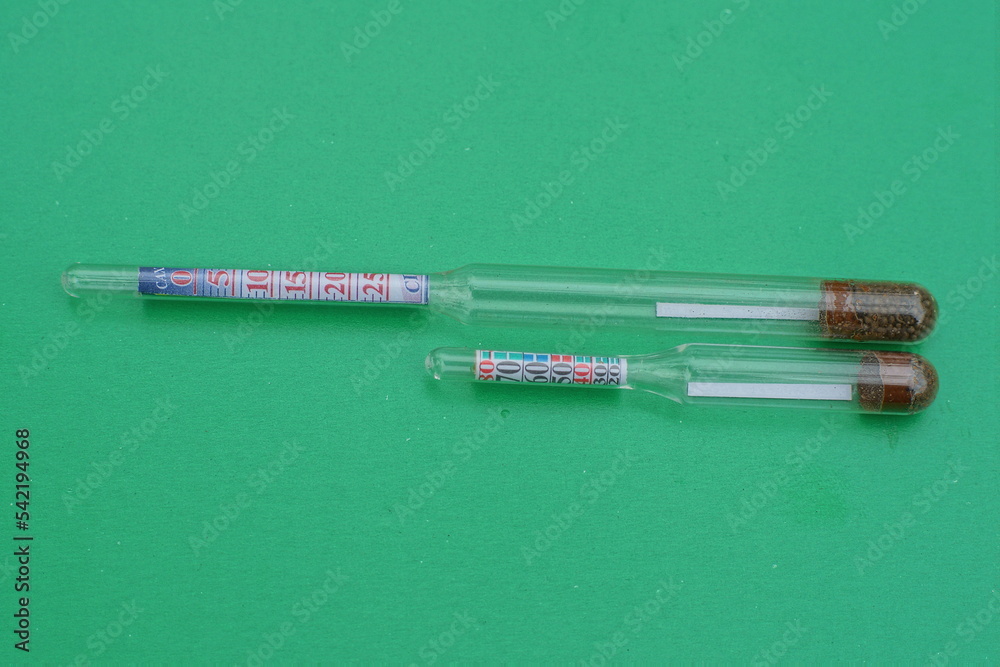 two different glass industrial ones with a paper scale inside an ...