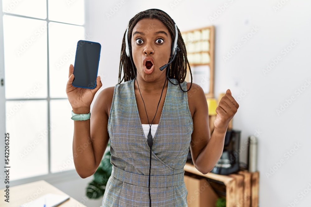 Young african american woman working at the office wearing operator ...