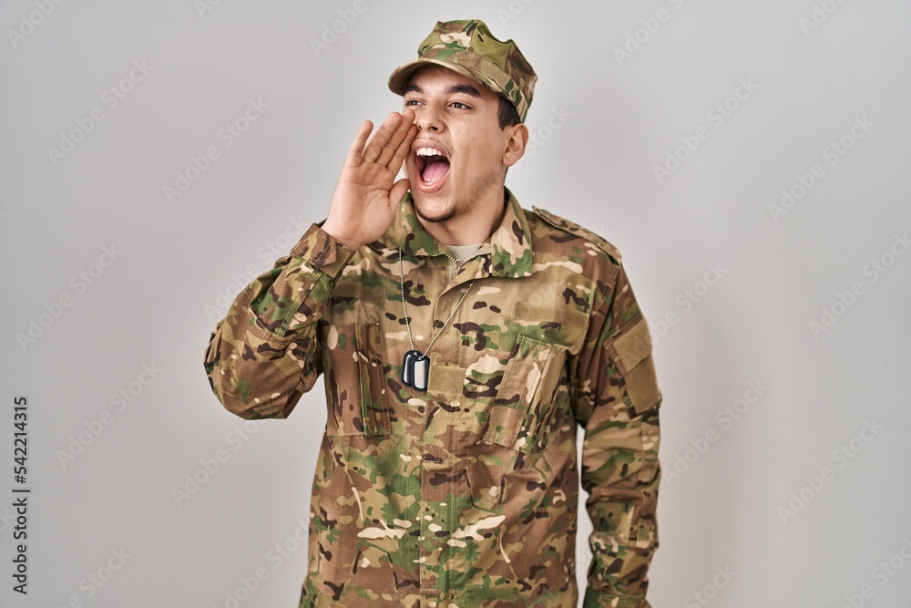 Young arab man wearing camouflage army uniform shouting and screaming ...