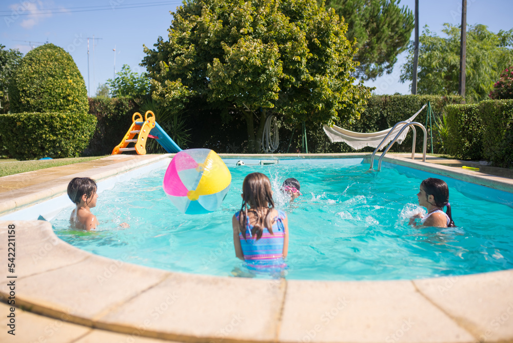 Portrait of four children enjoying game in pool. Happy boys and girls ...