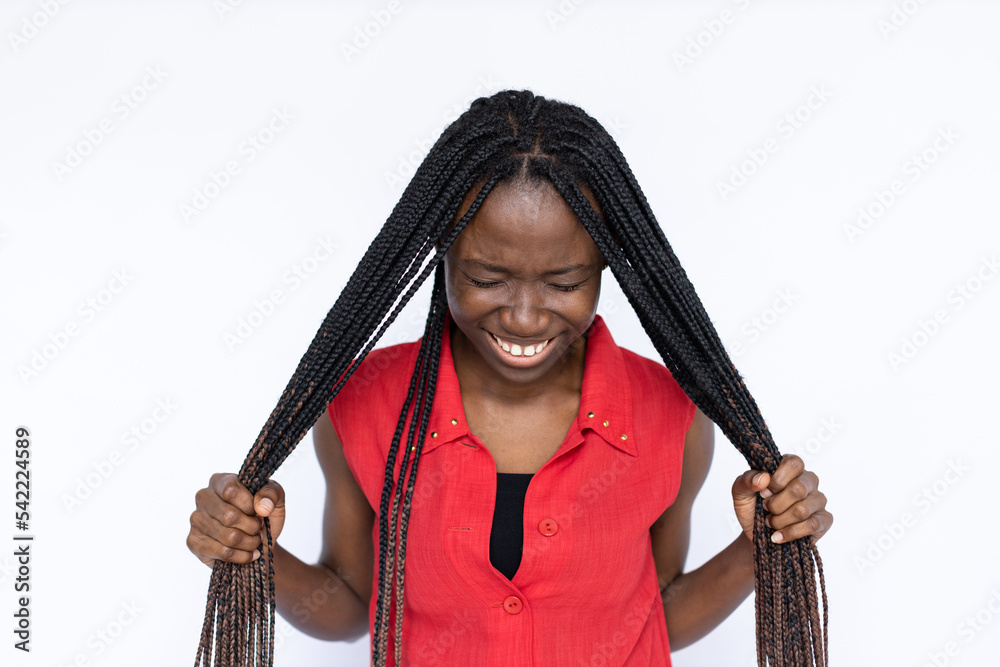 Smiling woman pulling down hair. Female African American model in red ...