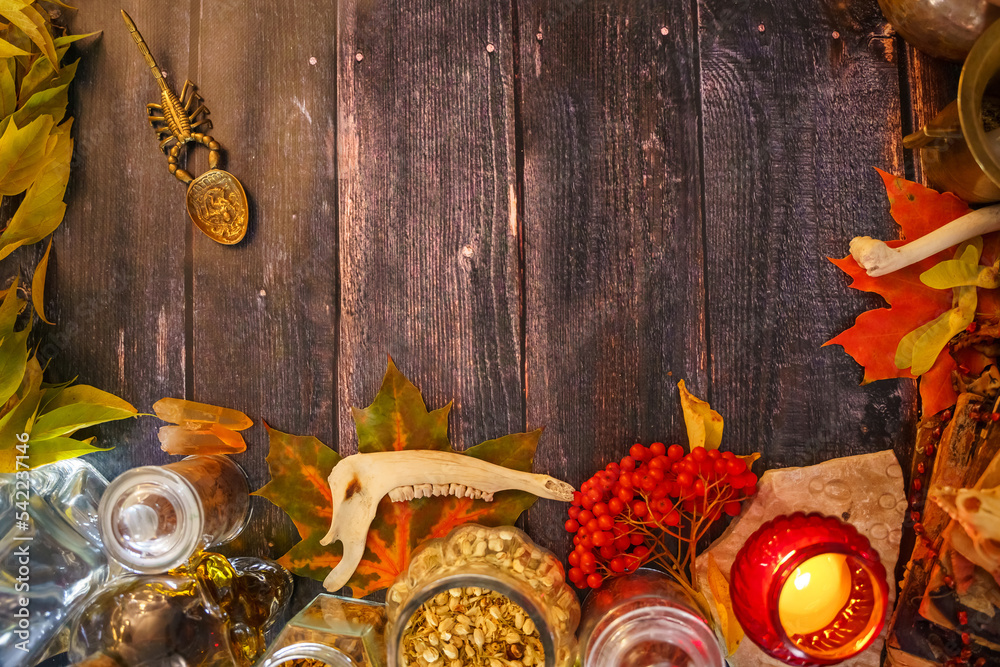 Occult altar background with autumn leaves décor, bones, bottles with ...