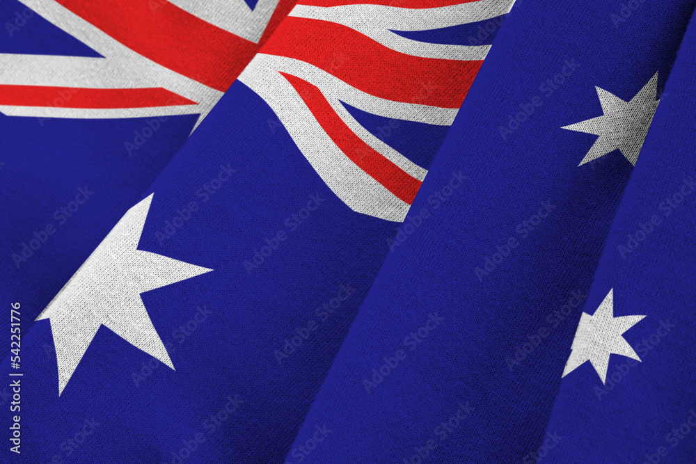 Australia flag with big folds waving close up under the studio light ...