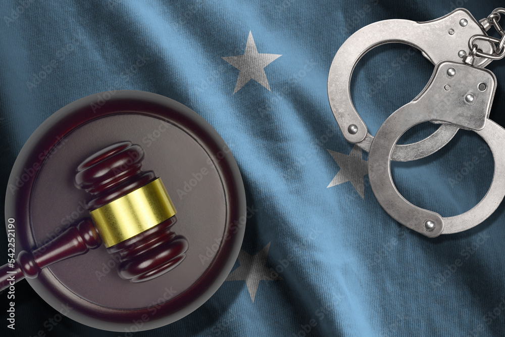 Micronesia flag with judge mallet and handcuffs in dark room. Concept ...