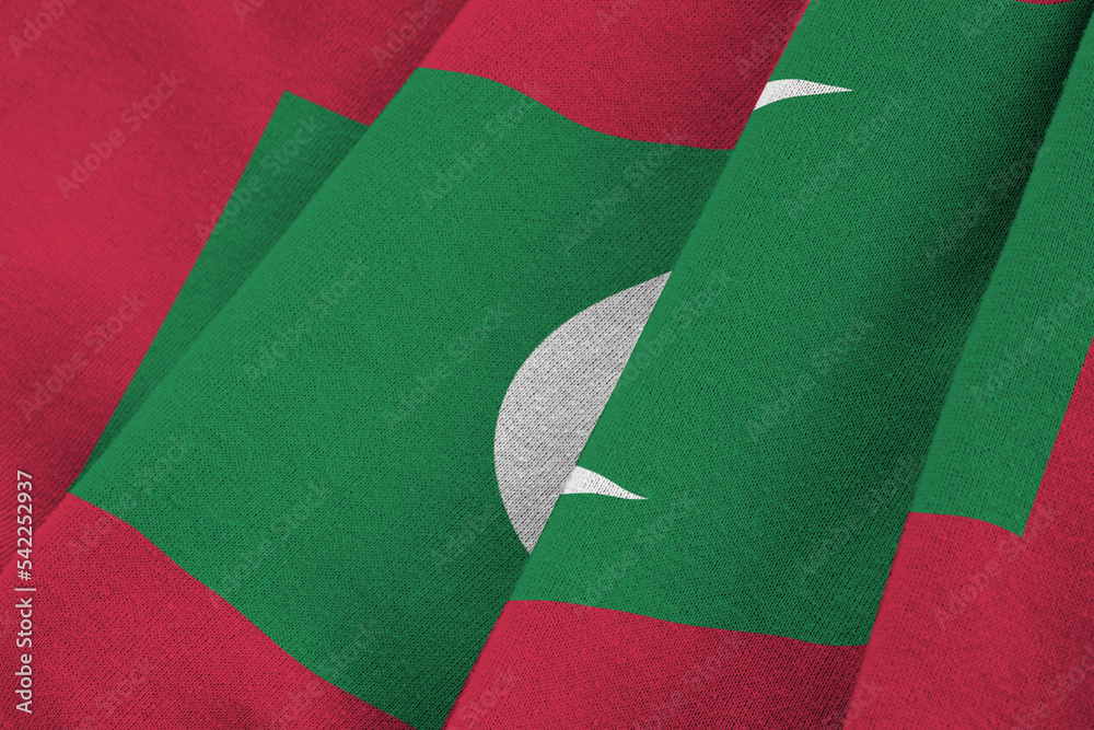 Maldives flag with big folds waving close up under the studio light ...