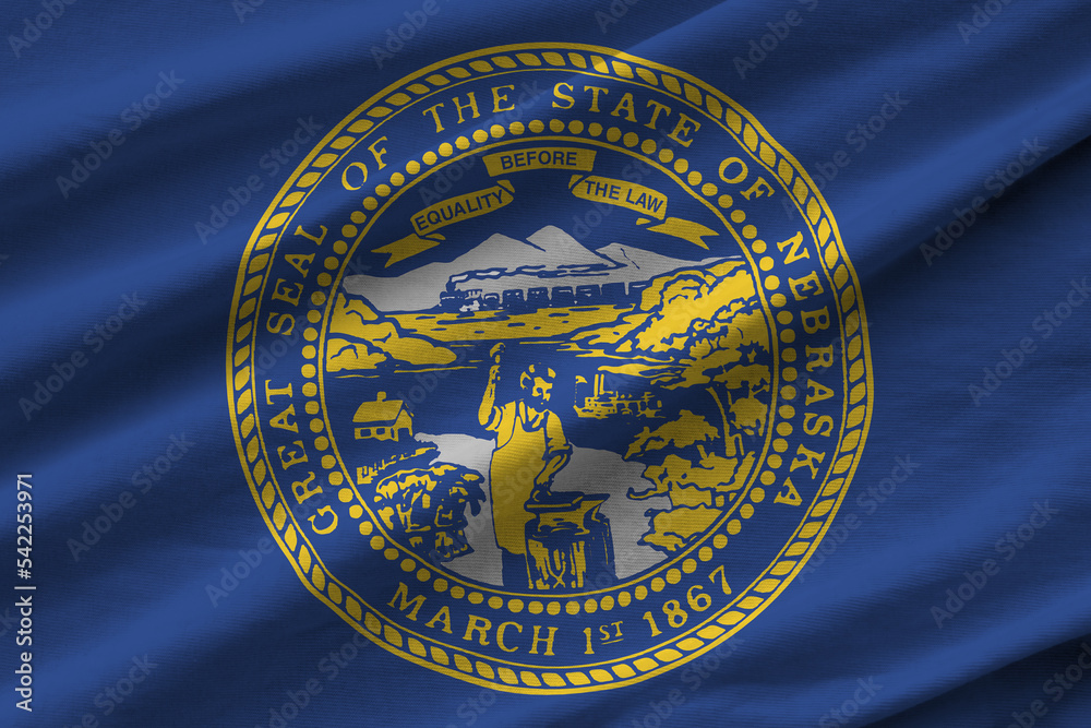 Foto de Nebraska US state flag with big folds waving close up under the ...