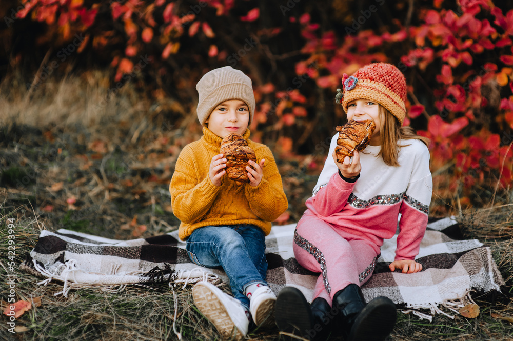 Handsome boy child of preschool age and his friend a smiling girl eat a ...