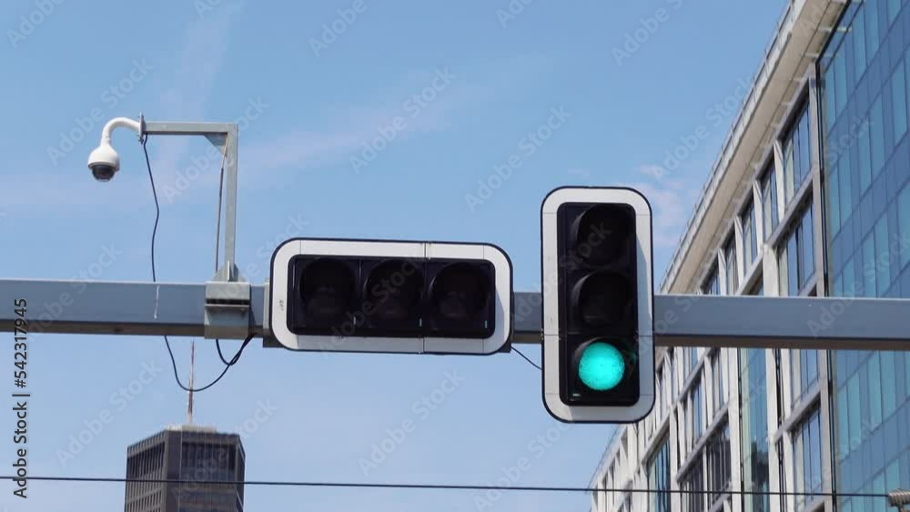 Operating traffic lights control movement of cars on road against blue ...