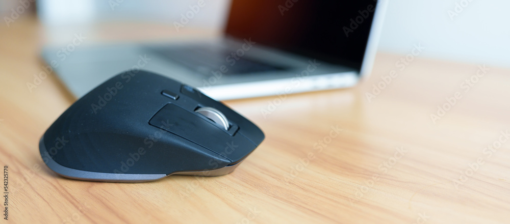 Ergonomic vertical mouse with laptop computer on adjustable desk at ...