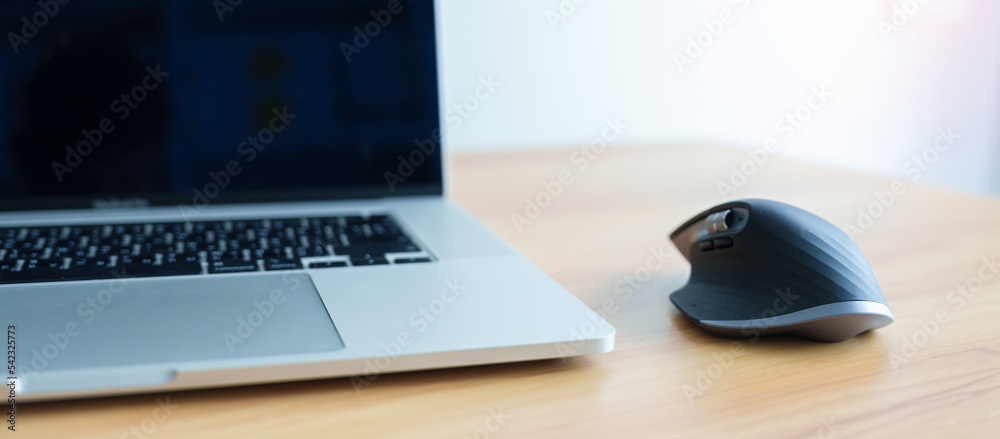 Ergonomic vertical mouse with laptop computer on adjustable desk at ...