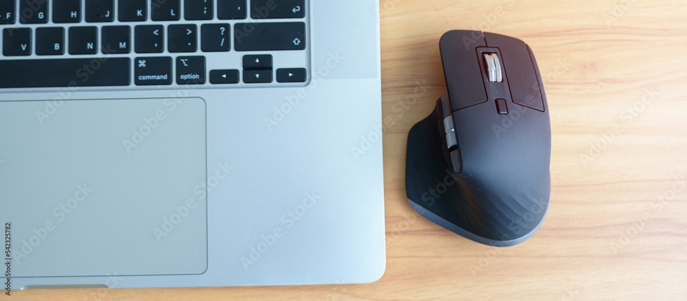 Ergonomic vertical mouse with laptop computer on adjustable desk at ...