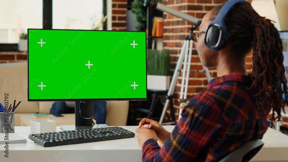 Female manager analyzing greenscreen template on monitor, working with ...
