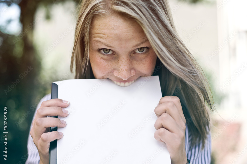 Germany, Duesseldorf, Young woman biting folder, portrait Stock Photo ...