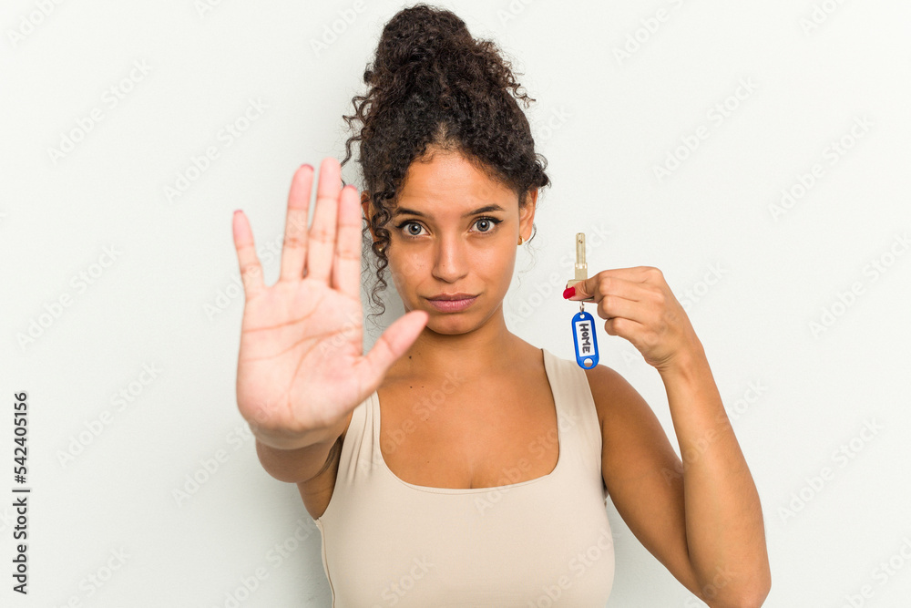 Young brazilian woman holding home keys isolated standing with ...