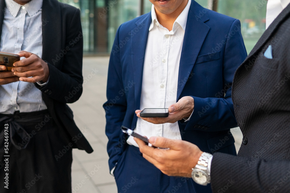 Crop multiethnic colleagues using smartphones together Stock Photo ...