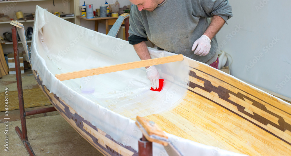 Carpenter making wooden boat of his own design in his workshop Stock ...