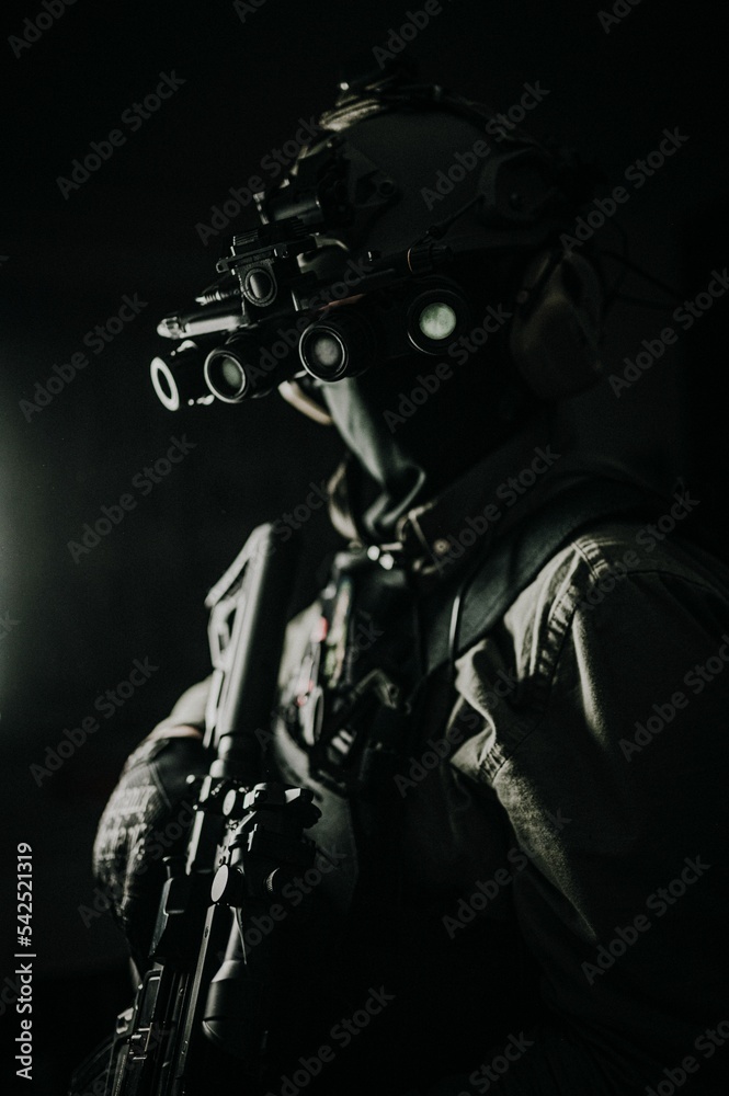 Vertical shot of soldier with gun wearing night vision goggles Stock ...