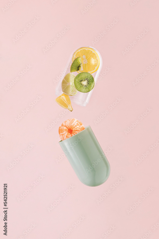 Green transparent pill with lemon, tangerine, kiwi and lime on isolated ...