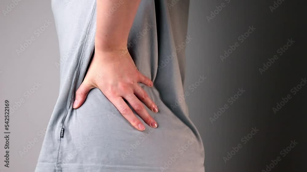 Lower back, loin ache. Hand grabbing spine in spasm, suffering from ...