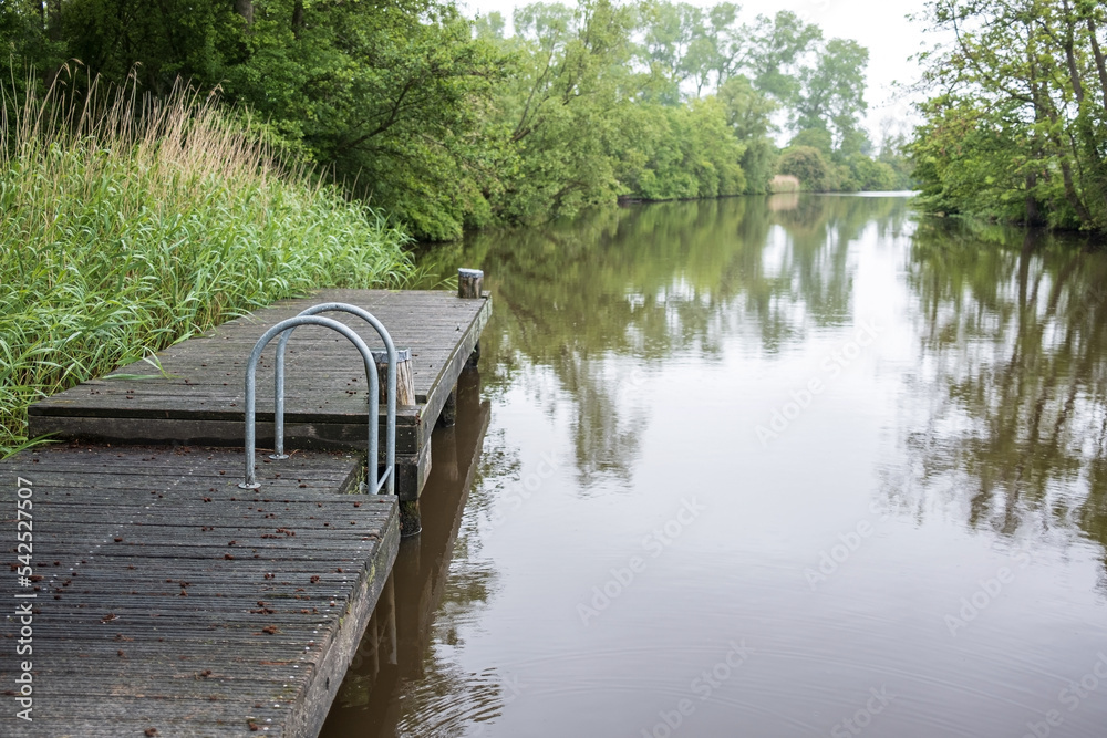 Wooden pier with a metal ladder for easy entry into the water, on the ...