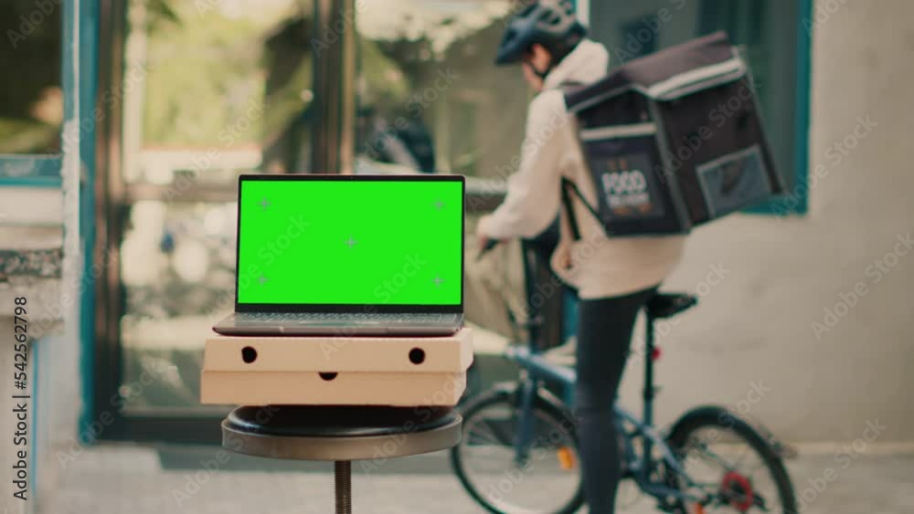 Laptop showing greenscreen display outdoors, food delivery service at ...