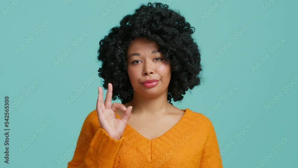Beautiful African American woman with curly hair looking unconvinced ...